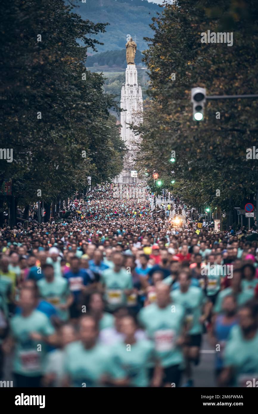 Many runners in the Bilbao Night Marathon, running in the streets of ...