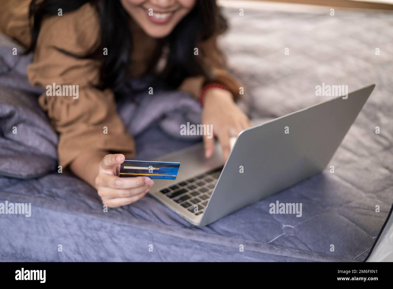 Asian woman using credit card shopping online with computer laptop ...