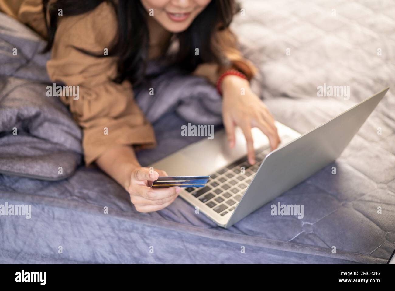 Asian woman using credit card shopping online with computer laptop ...