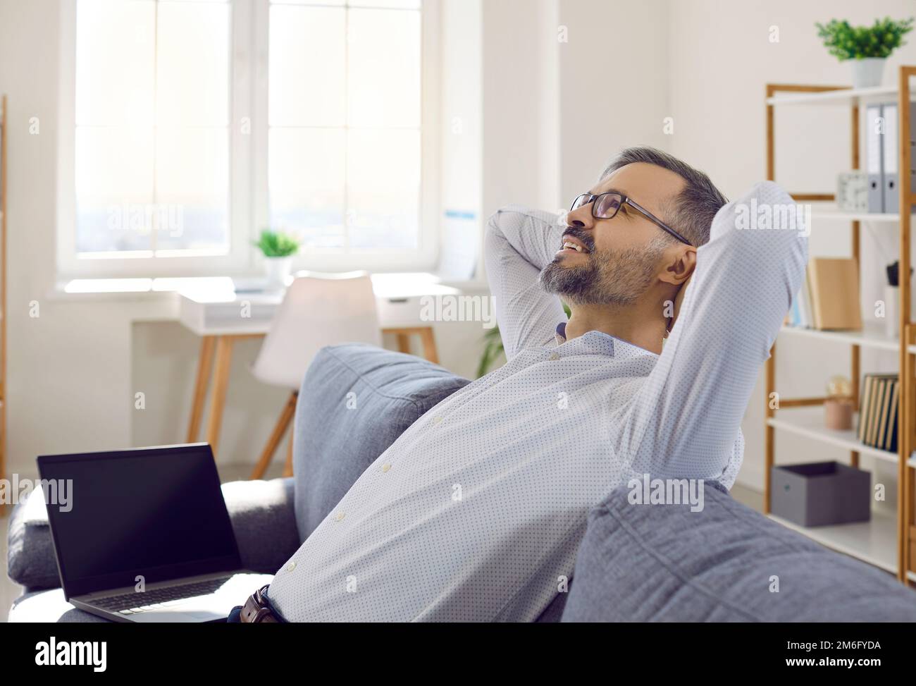 Man who is satisfied with his work relaxes and enjoys his free time ...