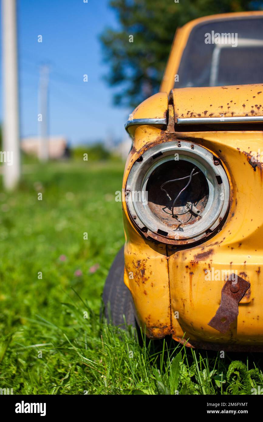 Old yellow wrecked car in vintage style. Abandoned rusty yellow car ...