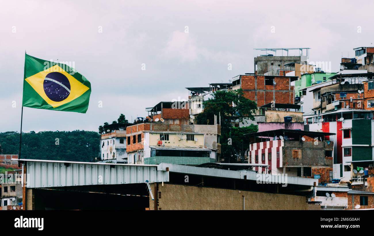 Flag of brazil on flagpole with slums in the background - social ...