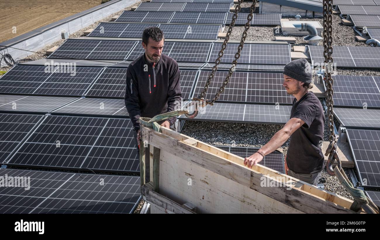 Male team engineers installing stand-alone solar photovoltaic panel ...