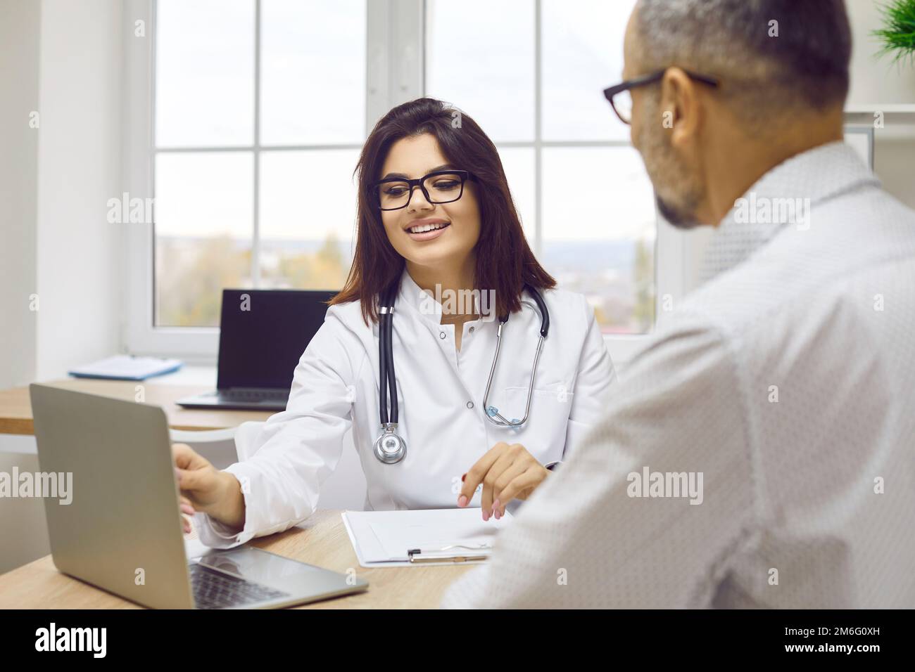 Doctor showing laptop with patient hi-res stock photography and images ...