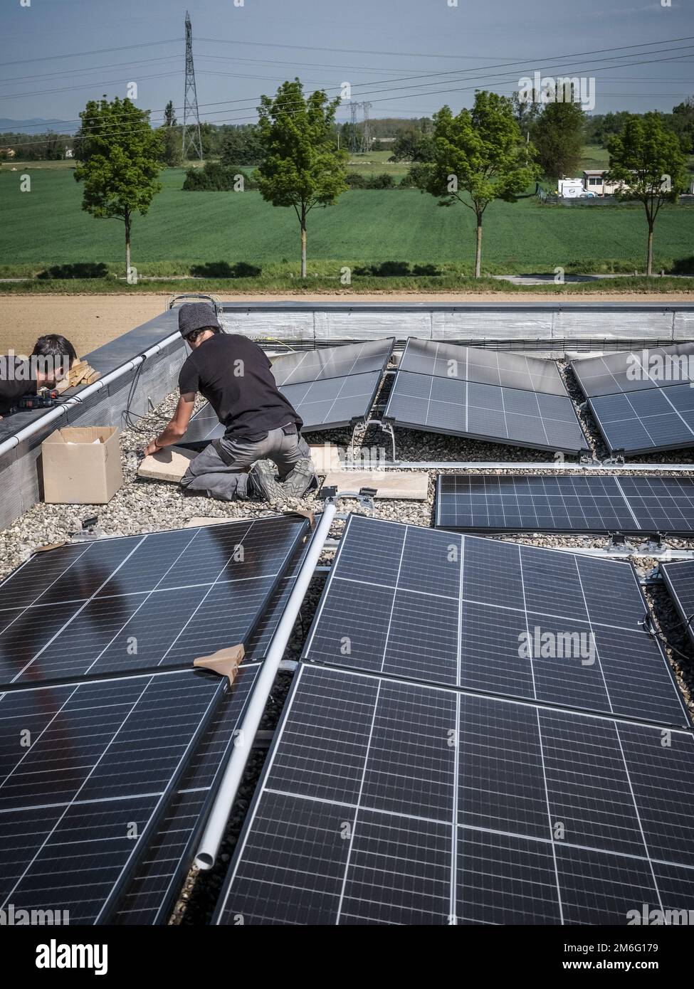 Male team engineers installing stand-alone solar photovoltaic panel ...