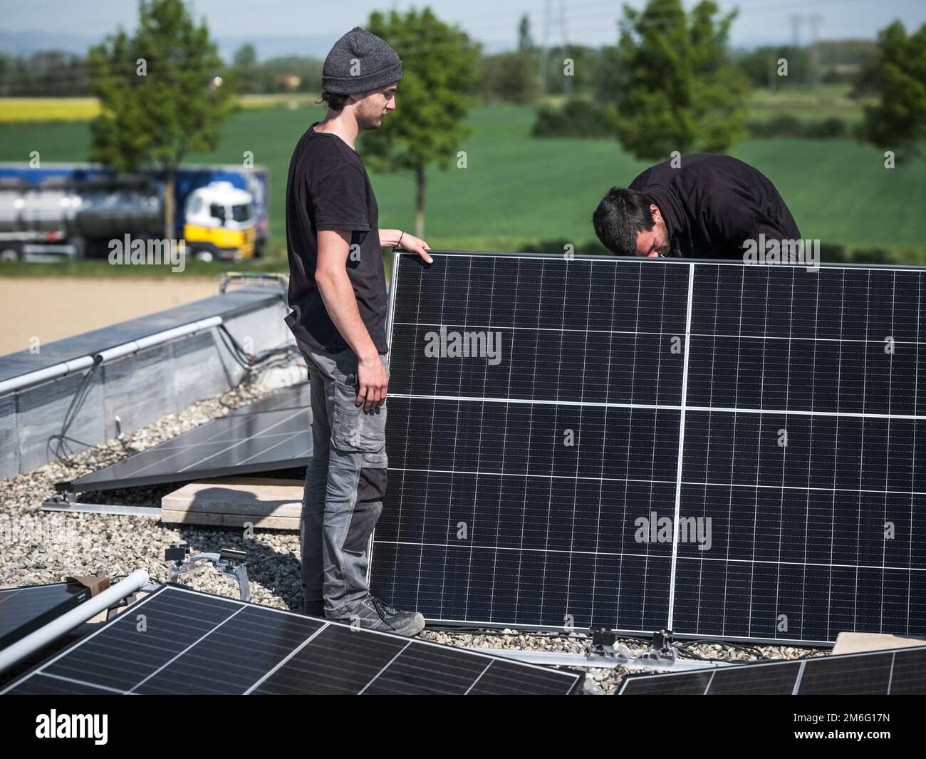Male team engineers installing stand-alone solar photovoltaic panel ...