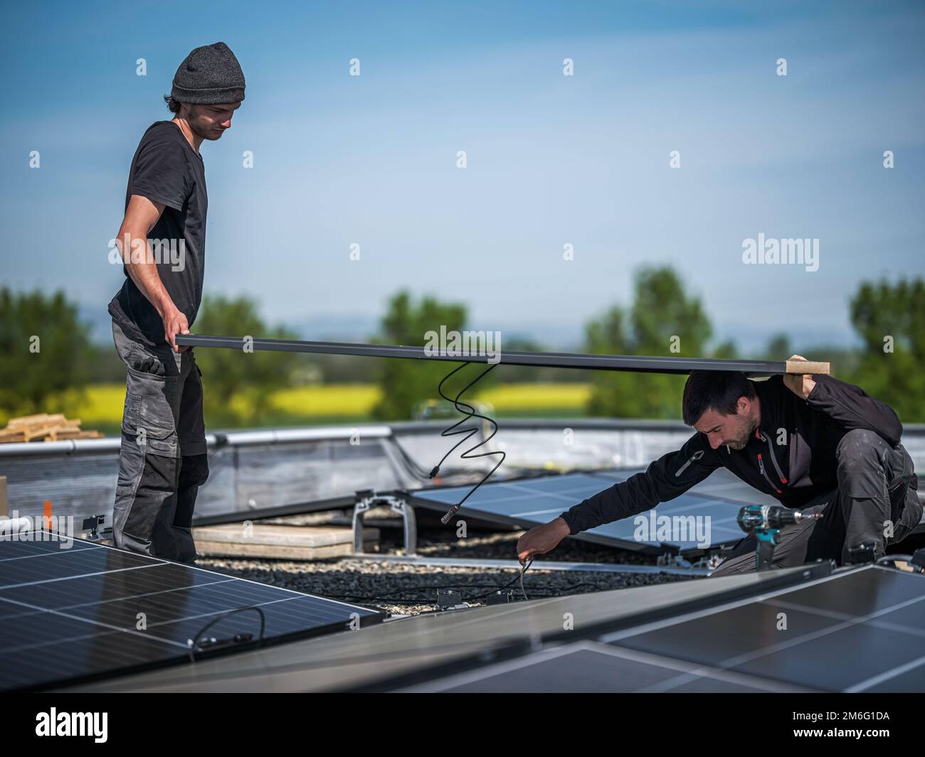 Male team engineers installing stand-alone solar photovoltaic panel ...