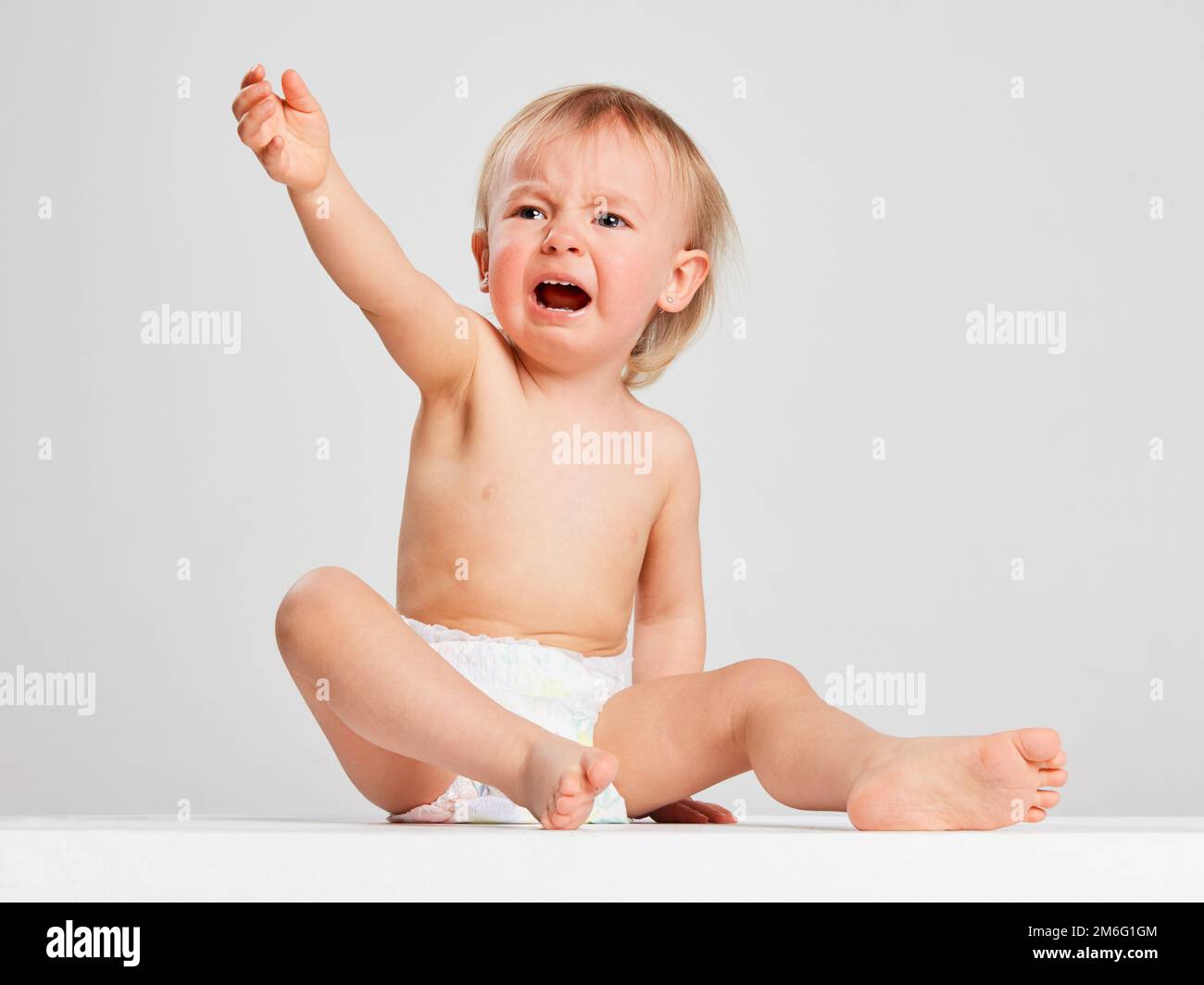 Crying baby. One little cute toddler girl, child in diaper posing ...