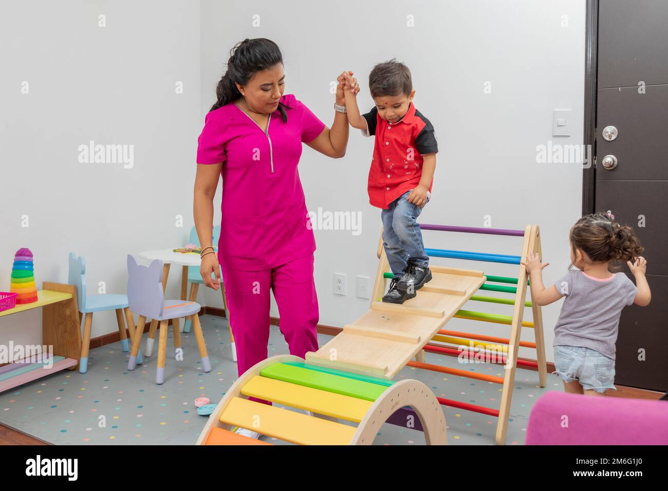 Pediatric doctor giving therapy to a child in the playground of her ...