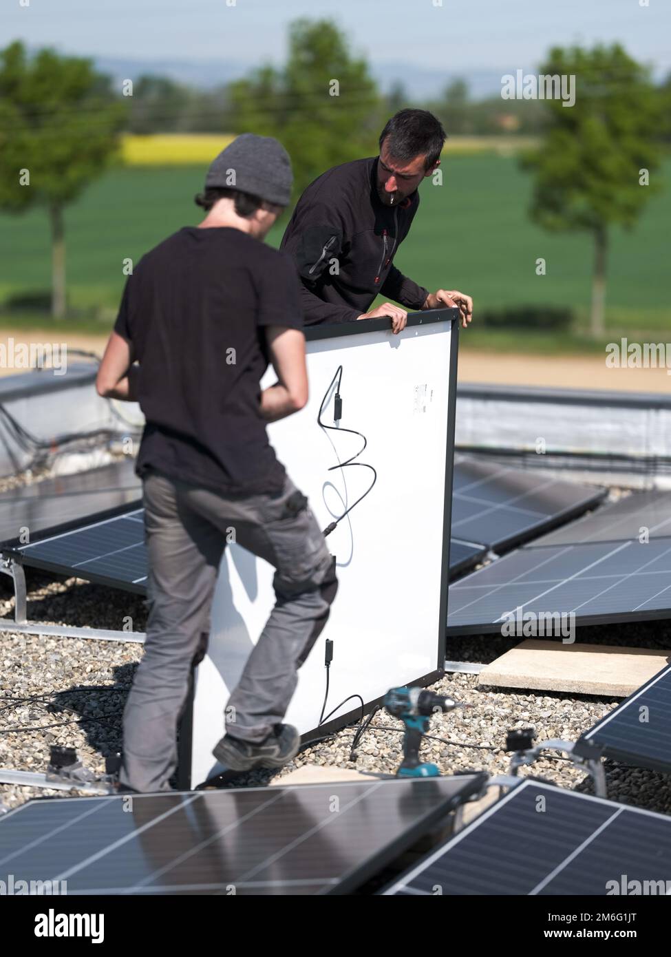 Male team engineers installing stand-alone solar photovoltaic panel ...