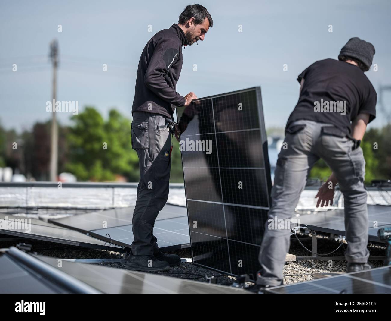 Male team engineers installing stand-alone solar photovoltaic panel ...