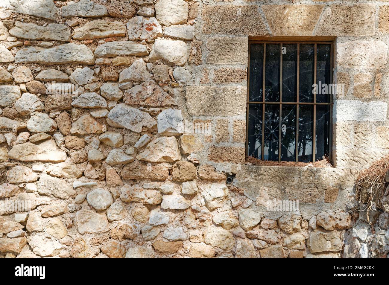 A stone wall with an old broken window and a lattice Stock Photo - Alamy
