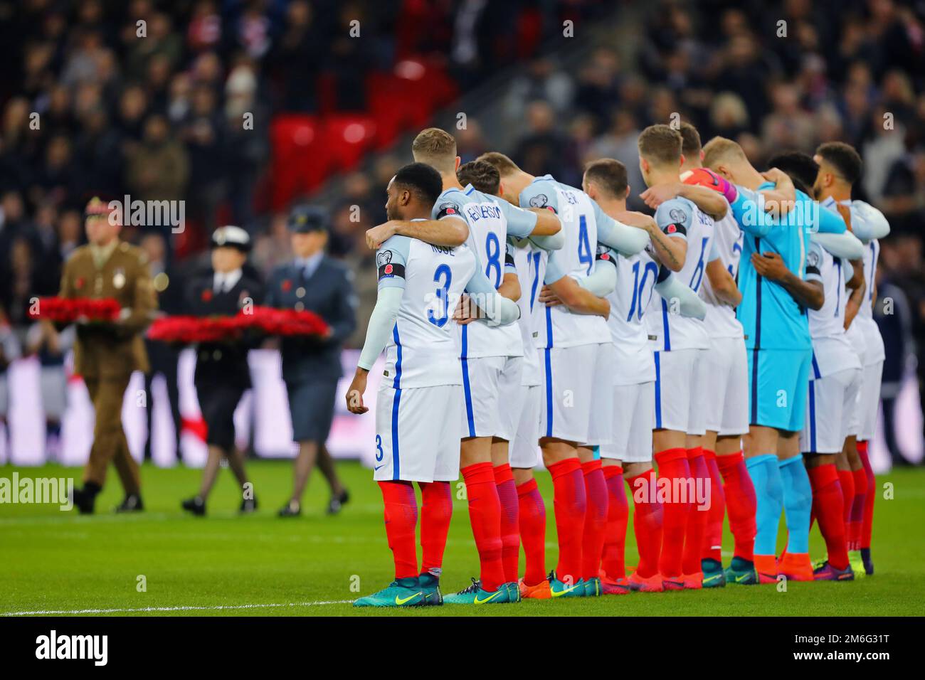 England team line up as Poppy wreaths are lead out onto the pitch ...