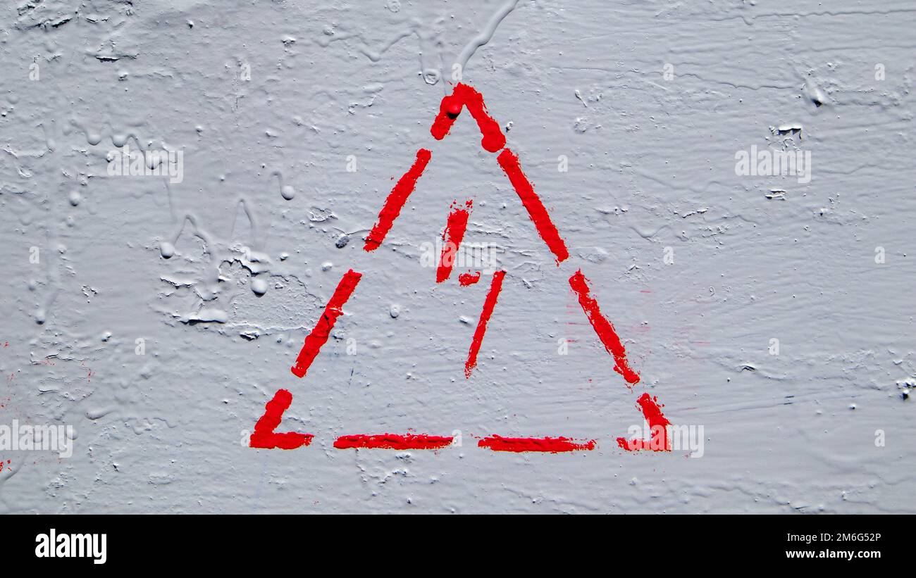 Red electrical hazard sign with lightning in a triangle on a gray ...