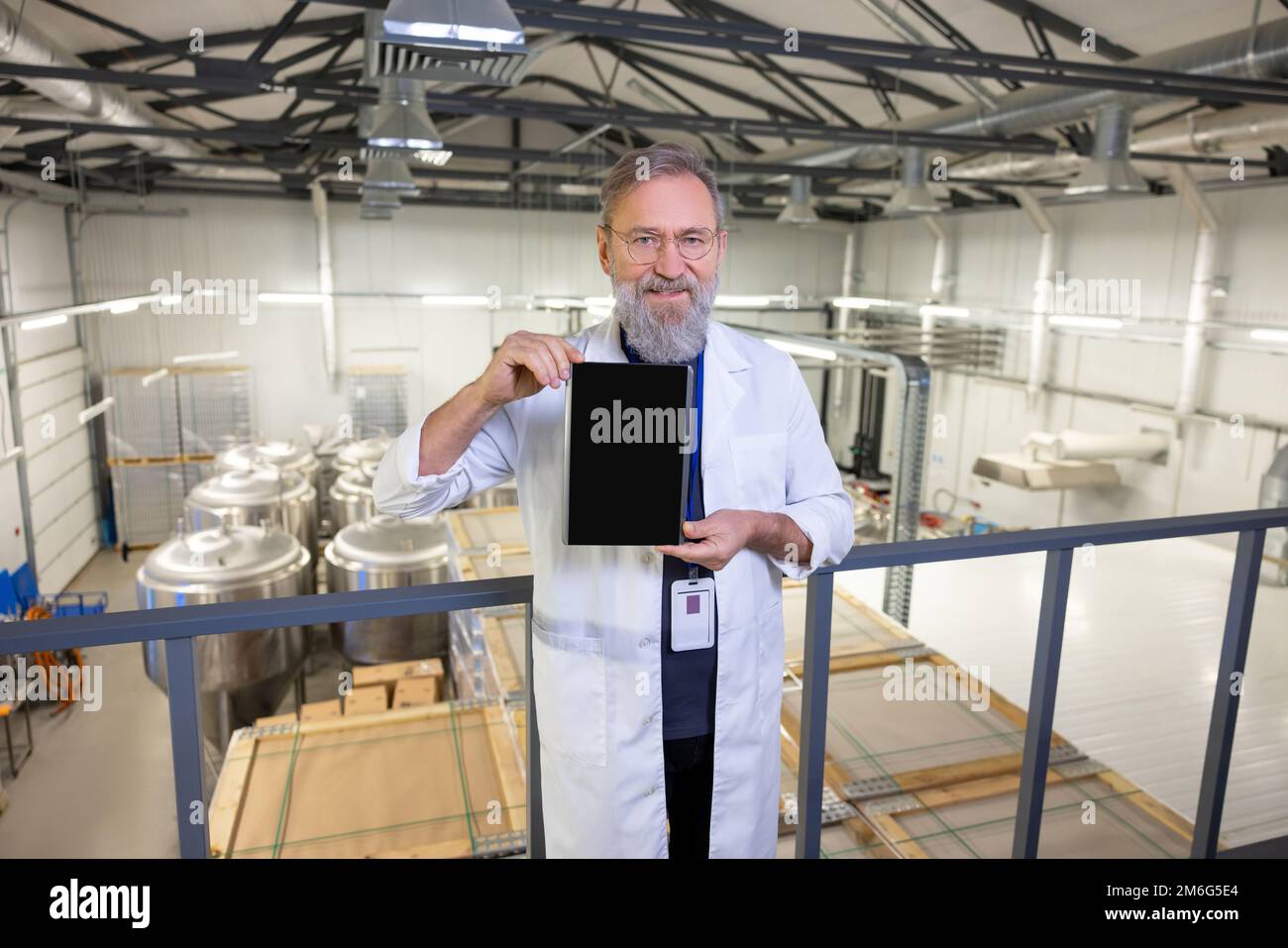 Contented brewer showing off his digital device before the camera Stock ...