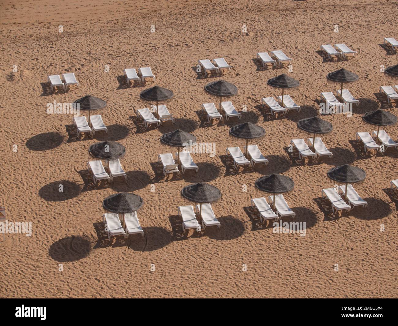 Sun beds and umbrellas on the sandy beach Stock Photo - Alamy