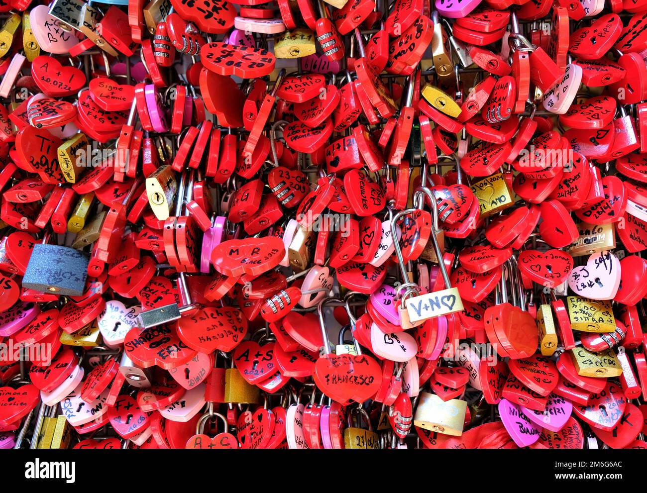 Red locks in the shape of hearts on a fence Stock Photo - Alamy