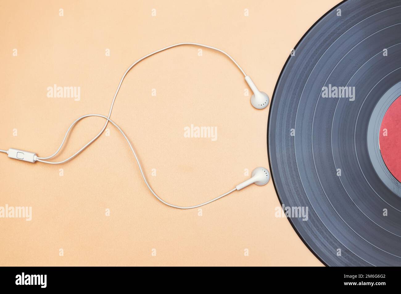 Modern small headphones and a vintage vinyl record Stock Photo - Alamy