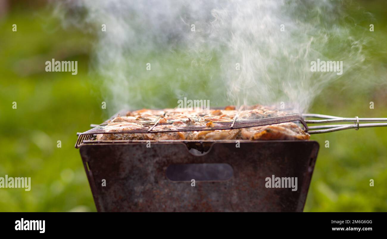 Meat pieces strung on metal skewers on the grill at sunset Stock Photo ...