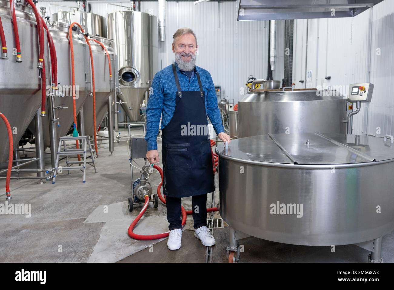 Factory worker standing near the tank with beer Stock Photo - Alamy