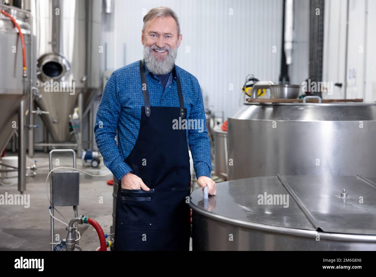 Factory worker standing near the tank with beer Stock Photo - Alamy