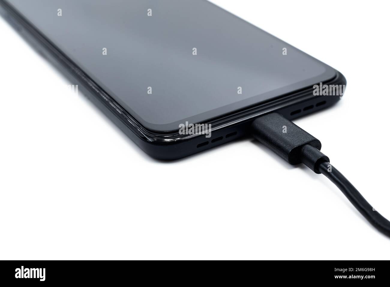 Smartphone charging via usb cable on a white background. Wired charging ...