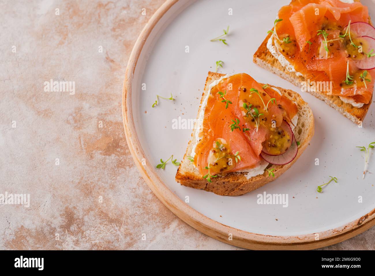 Two open sandwich, toast with salmon, cream cheese, avocado, cucumber ...