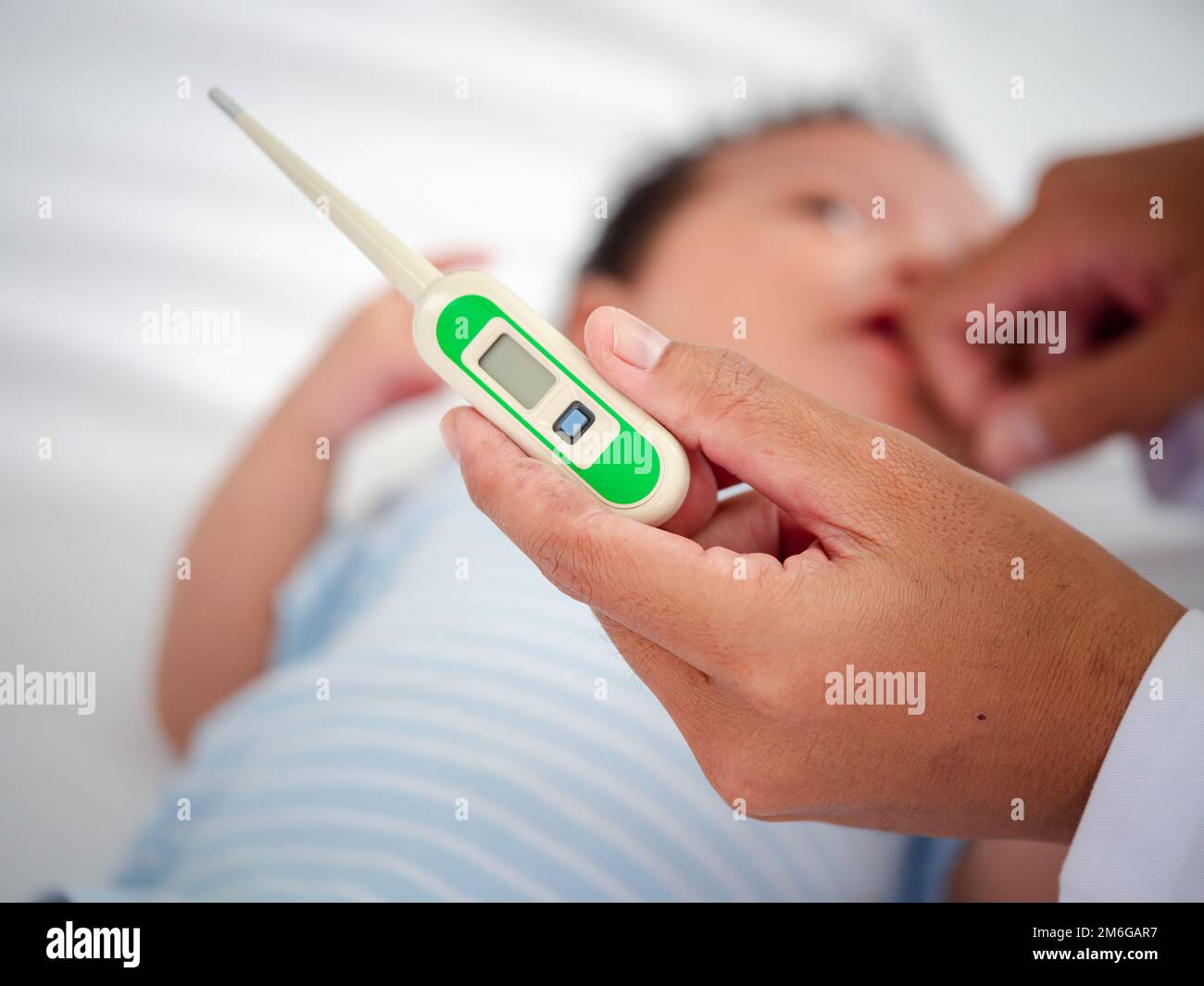 Baby illness medicine flu fever and thermometer, a doctor checks the ...