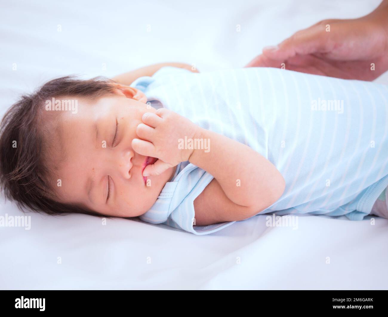 Portrait of three weeks Australian Asian newborn baby or infant lying ...