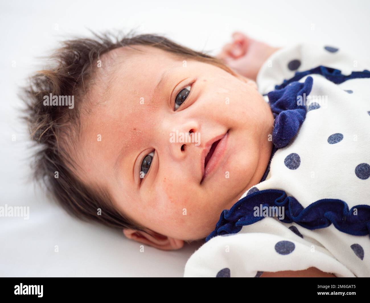 Portrait of three weeks Australian Asian newborn baby or infant lying ...