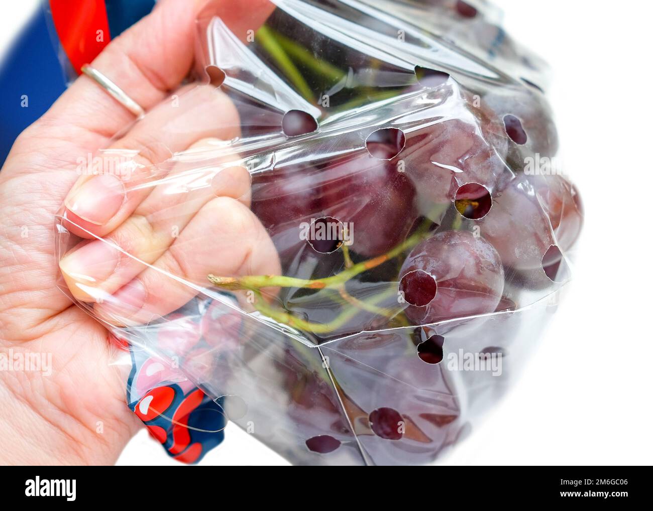 The hand stretches the package of grapes. Show package Stock Photo - Alamy