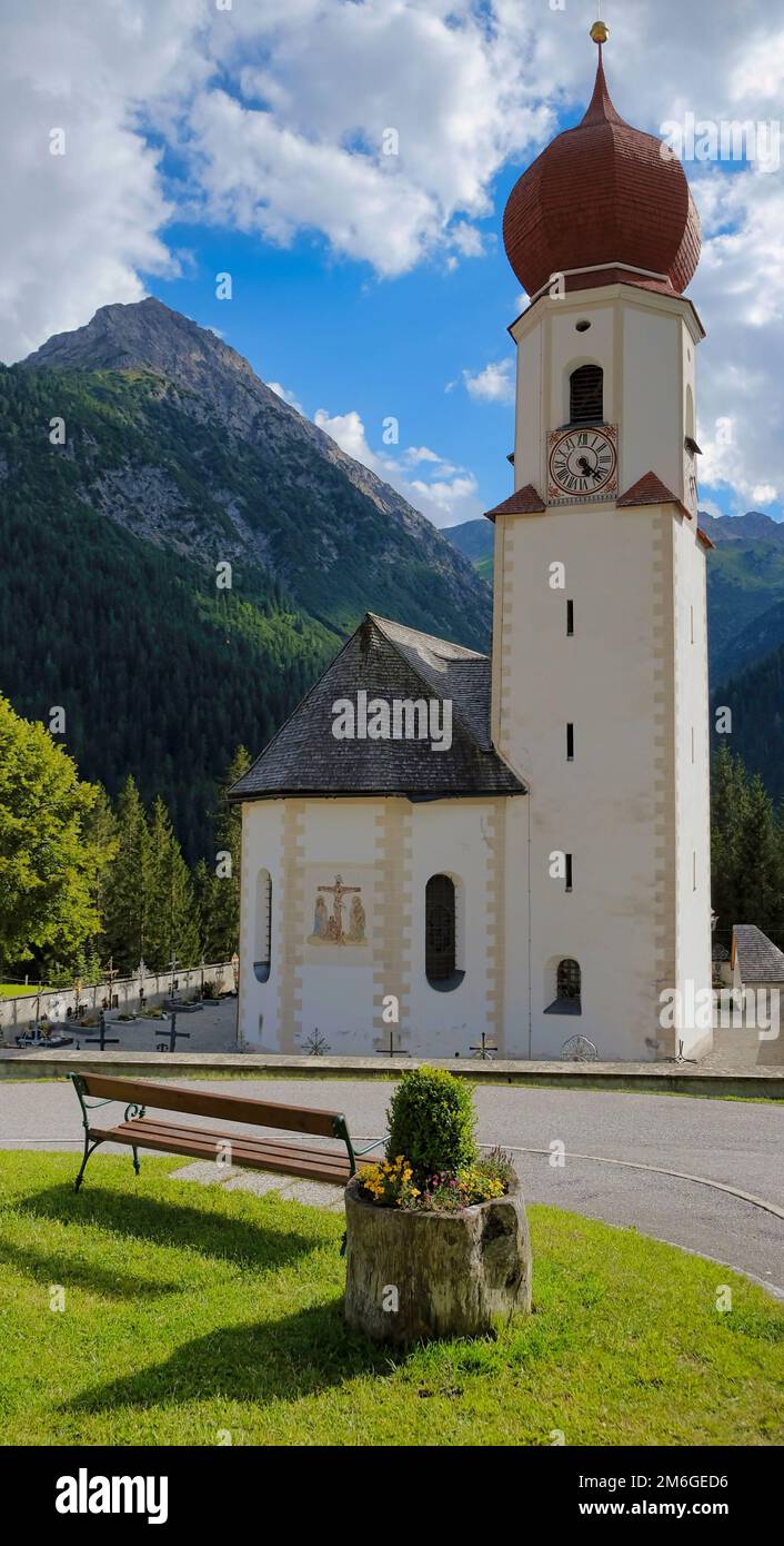 Church in the alps mountains sun grass clouds Stock Photo - Alamy