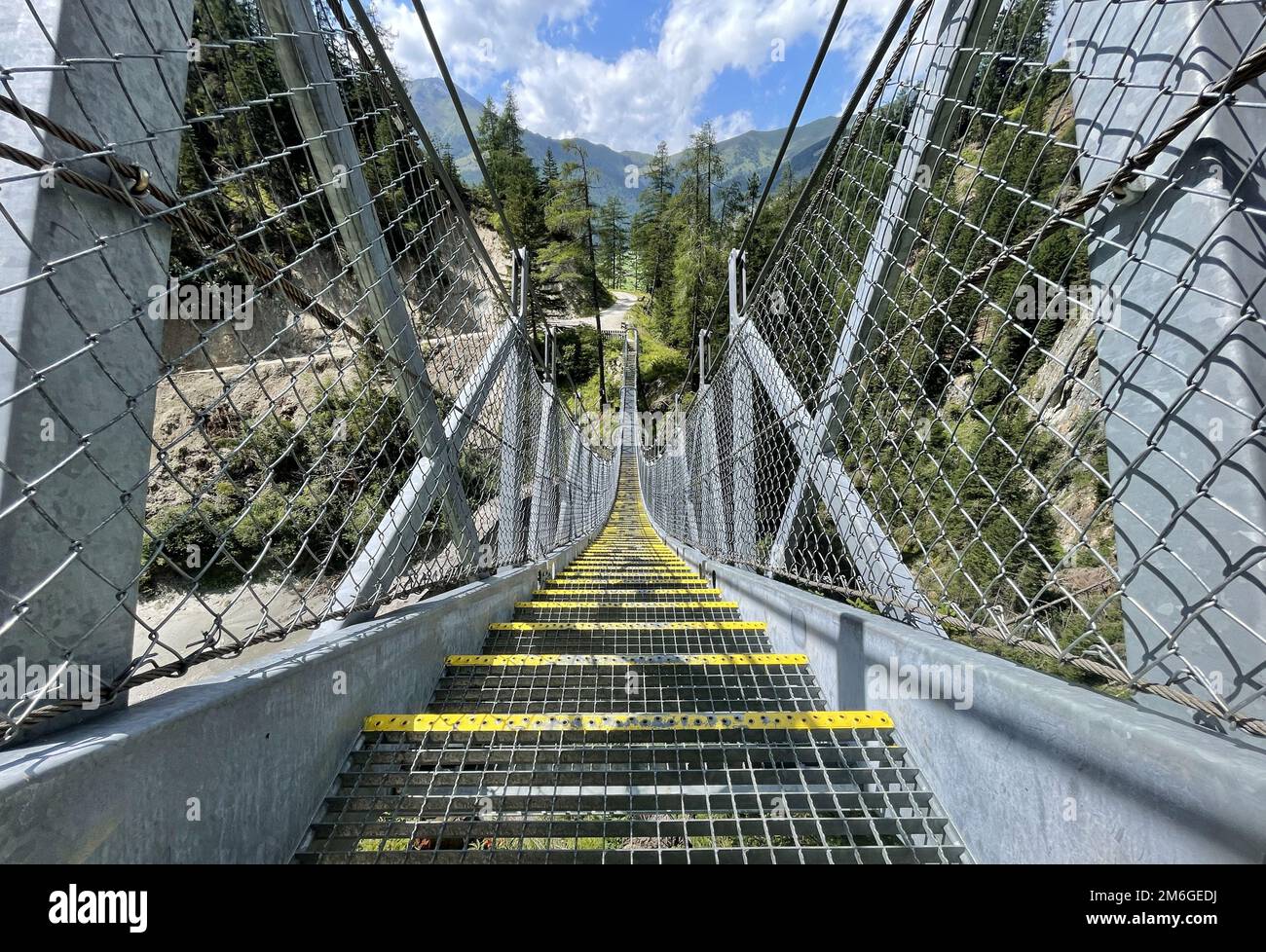 Suspension bridge between the trees in the alps mountains in Kals am ...
