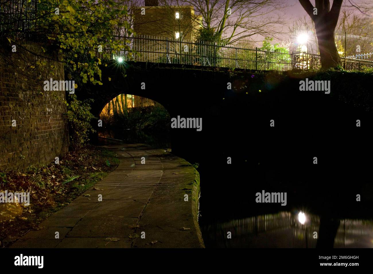 view of a footpath under a bridge on regent's canal at night in North ...