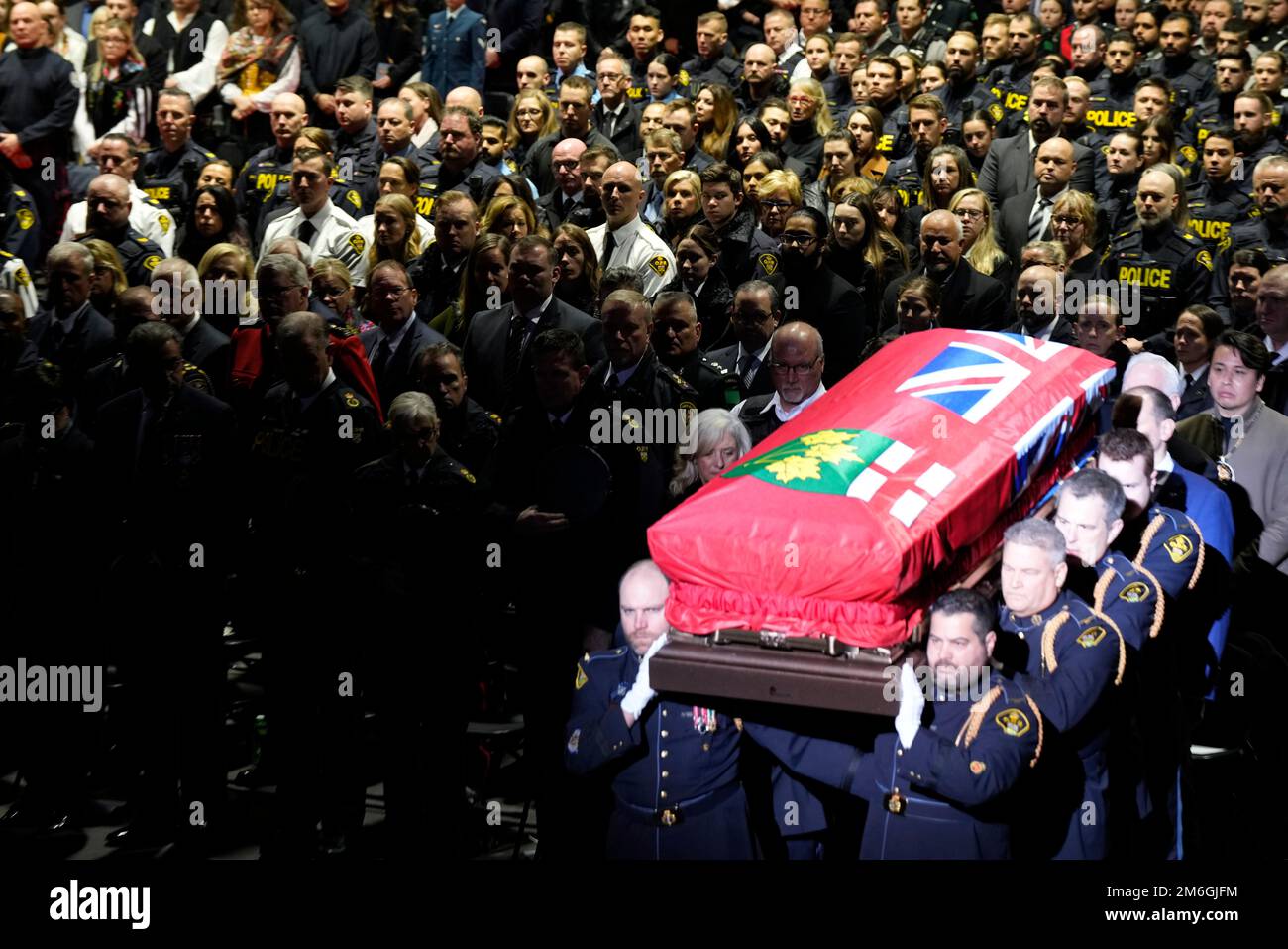 Members of the audience look on as pallbearers carry the casket of OPP ...