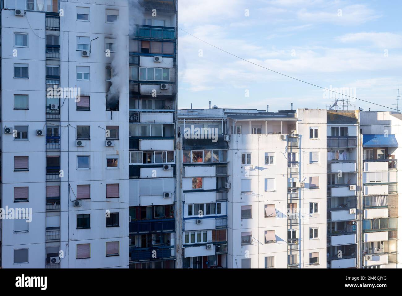 Smoke of a fire going out from an apartment building during the day ...