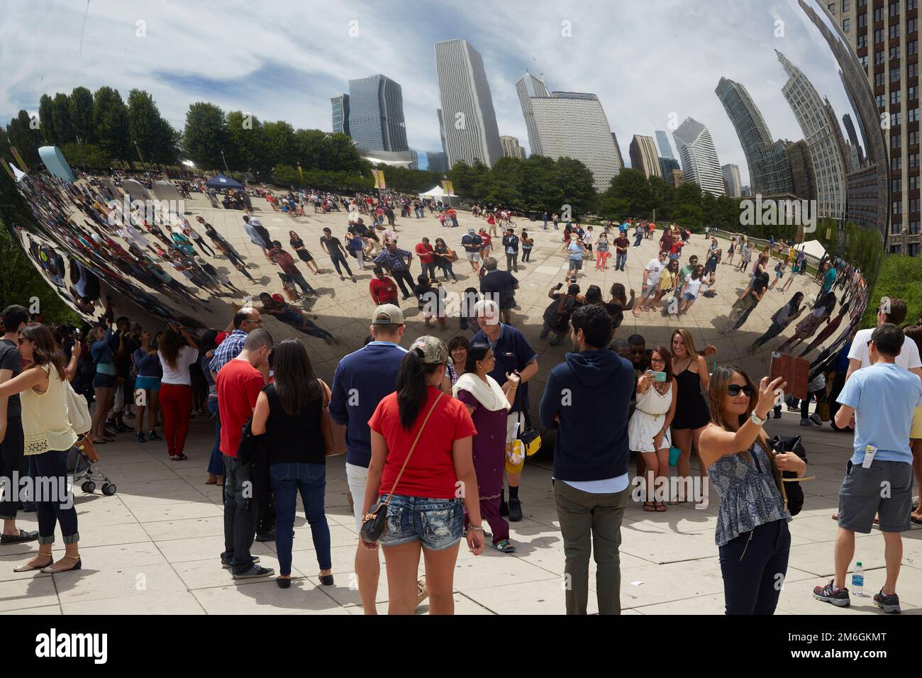 Tourists take photographs in front of Cloudgate aka The Bean, by Anish Kapoor in Millennium Park ...