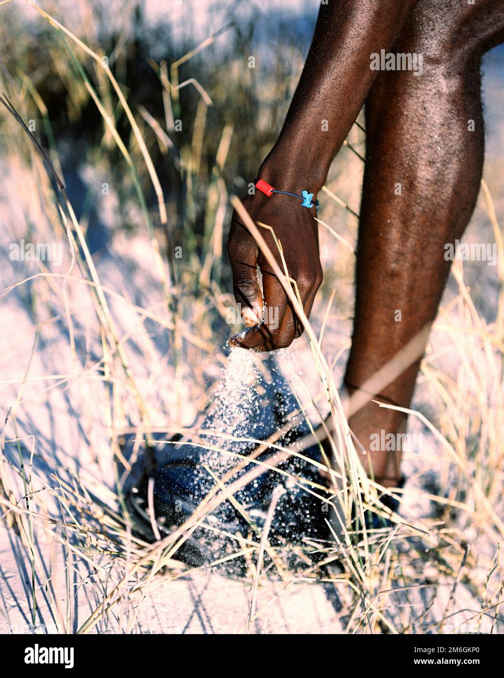 A vertical shot of a sand slipping through a hand of a black man Stock ...