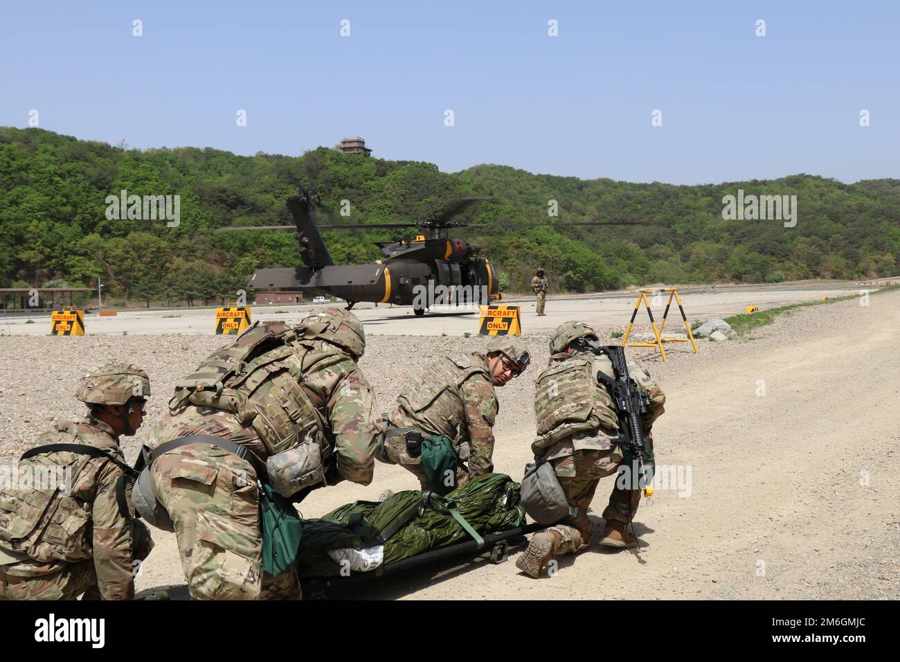 A team of Soldiers work together to approach a U.S. Army HH-60 medevac ...