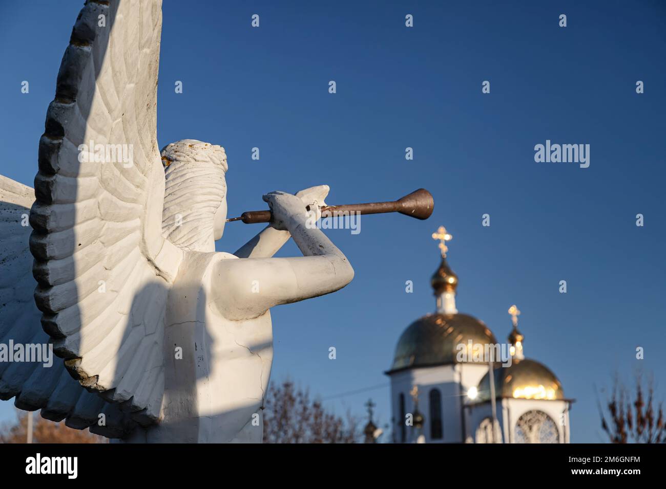 Sculpture of angel with a wind instrument against the background of the ...