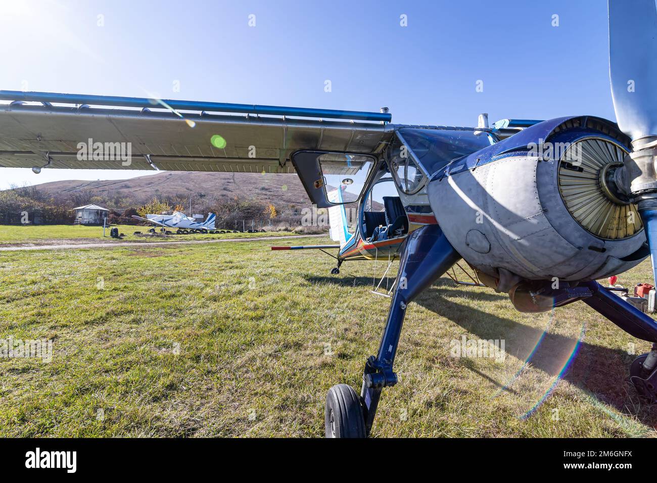 A small light-engine aircraft stands on a field airfield Stock Photo ...