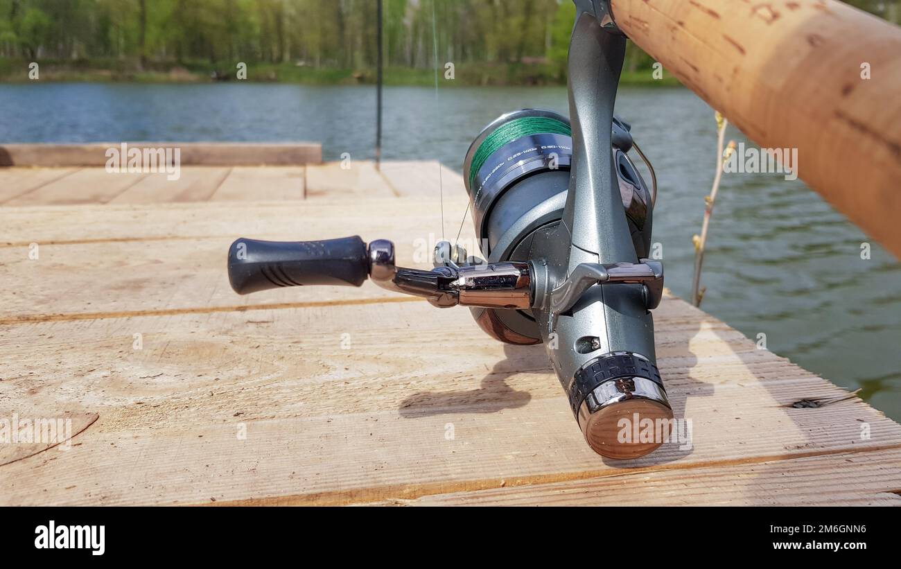 Carp fishing rod isolated on the lake and wooden bridge. Carp feeder ...