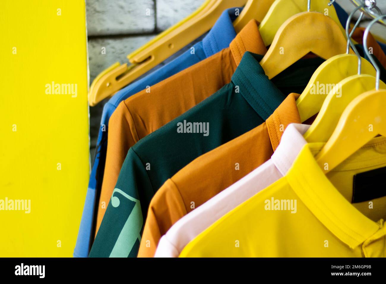 Cotton and sports t-shirts hung on wall hanger racks inside a clothes ...