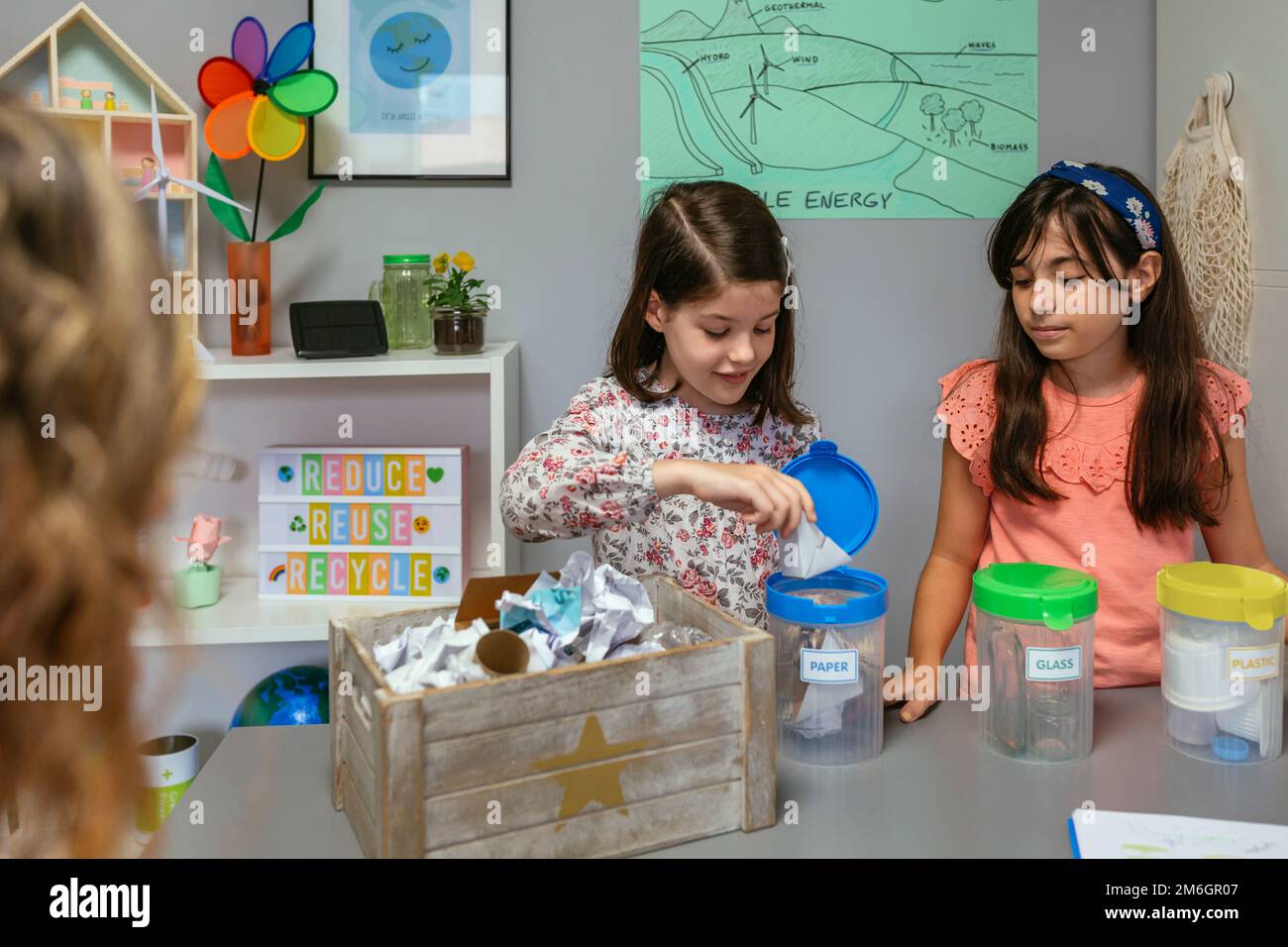Student recycling cardboard on selective trash bin in ecology classroom ...