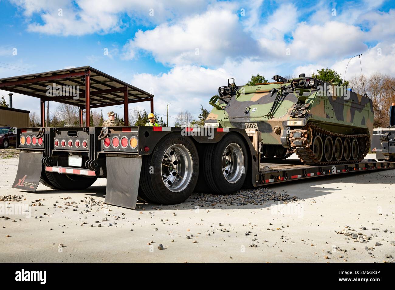 An M113 Armored Personnel Carrier is parked on a flatbed trailer at ...