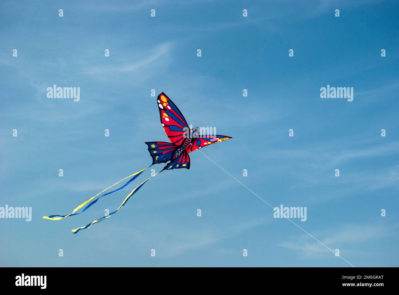 Children's butterfly kite flying on blue sky background Stock Photo - Alamy