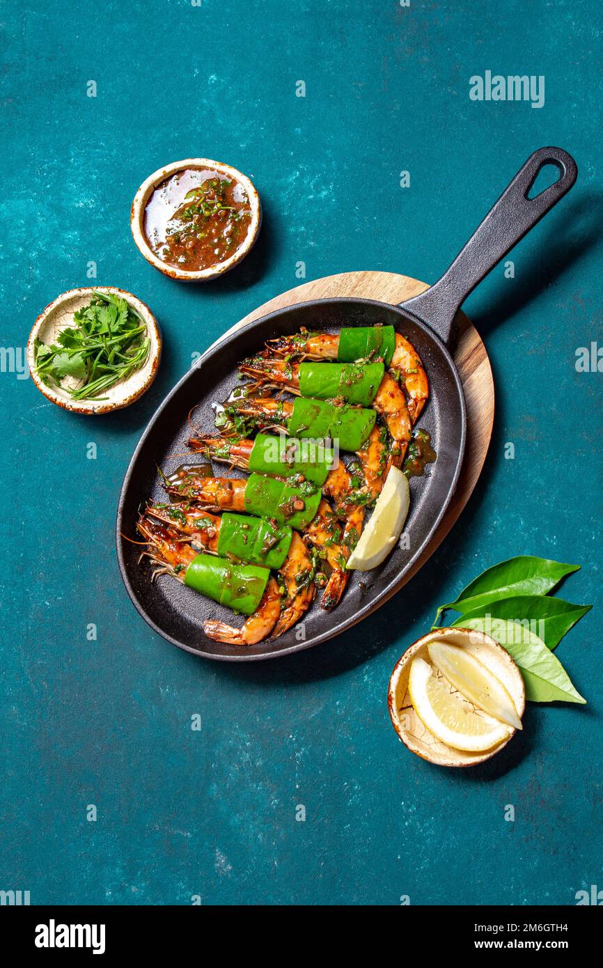 Spicy garlic tiger Prawns Shrimps on frying pan with lemon leaves on ...