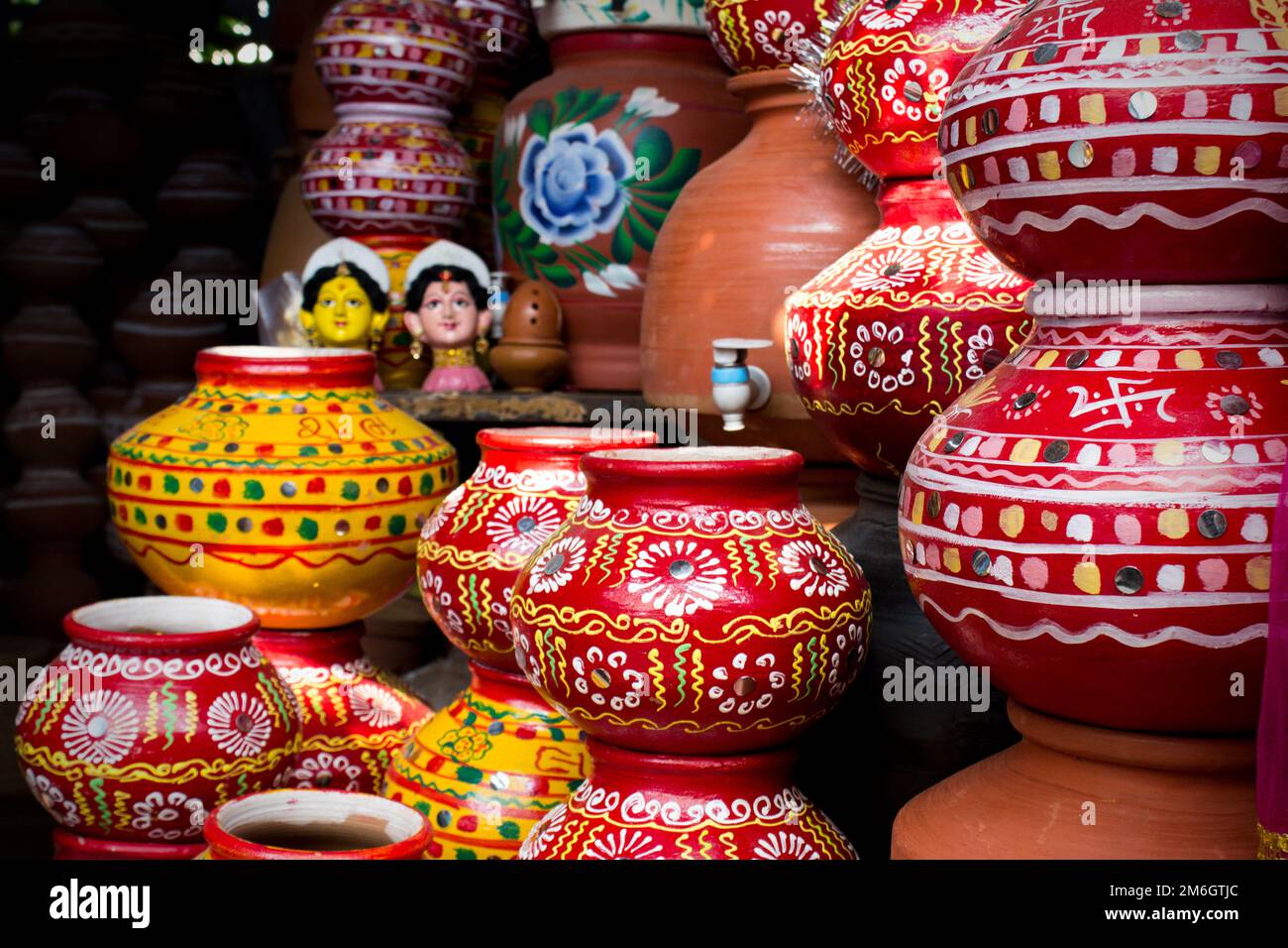Beautiful red Indian pots painted in white, green and yellow color ...