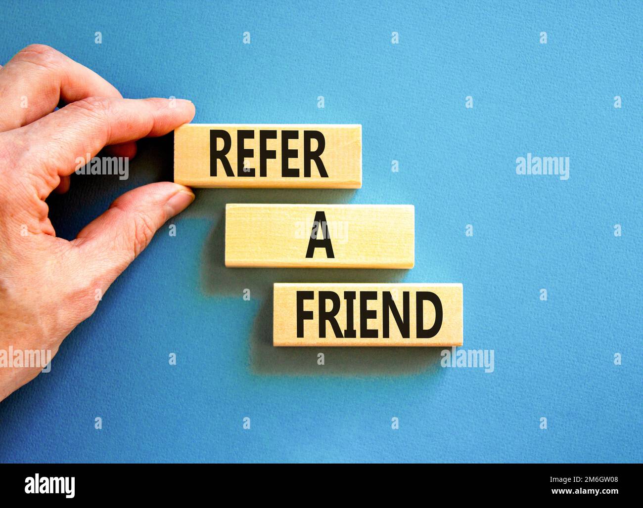 Refer a friend symbol. Concept words Refer a friend on wooden blocks on ...