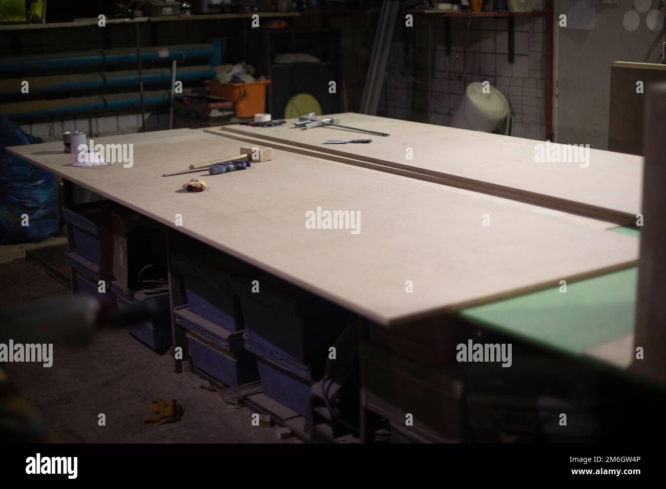 Table of workshop. Large board on table. Details of interior of working ...